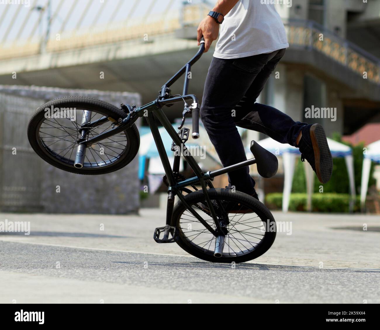 Showing off his skill. A cropped view of a cyclist doing a trick on his ...