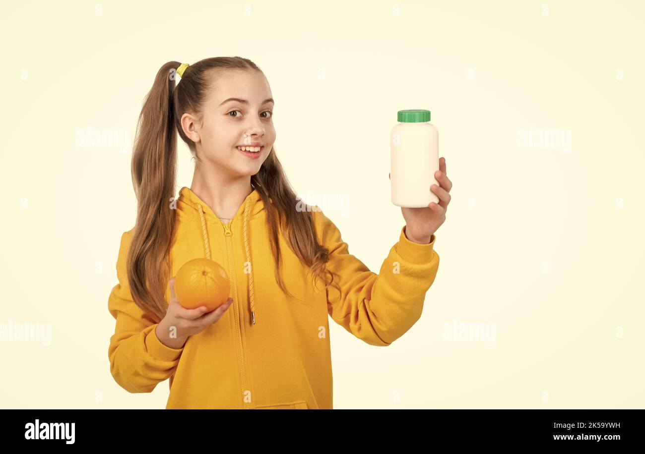 presenting vitamin product. child with orange flavored pill ...
