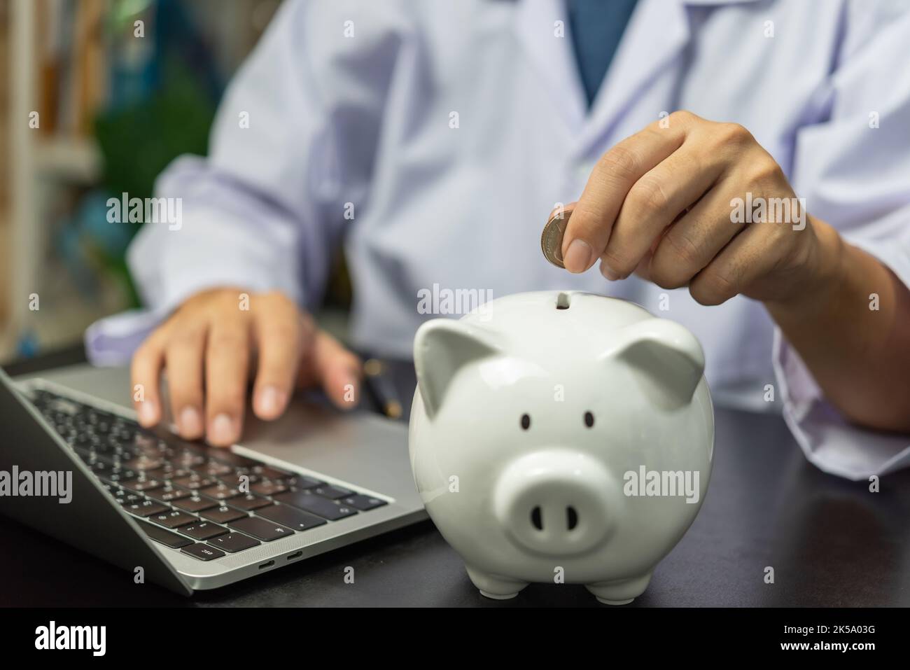 Doctor hand put coin in piggybank saving money insurance and planning ...