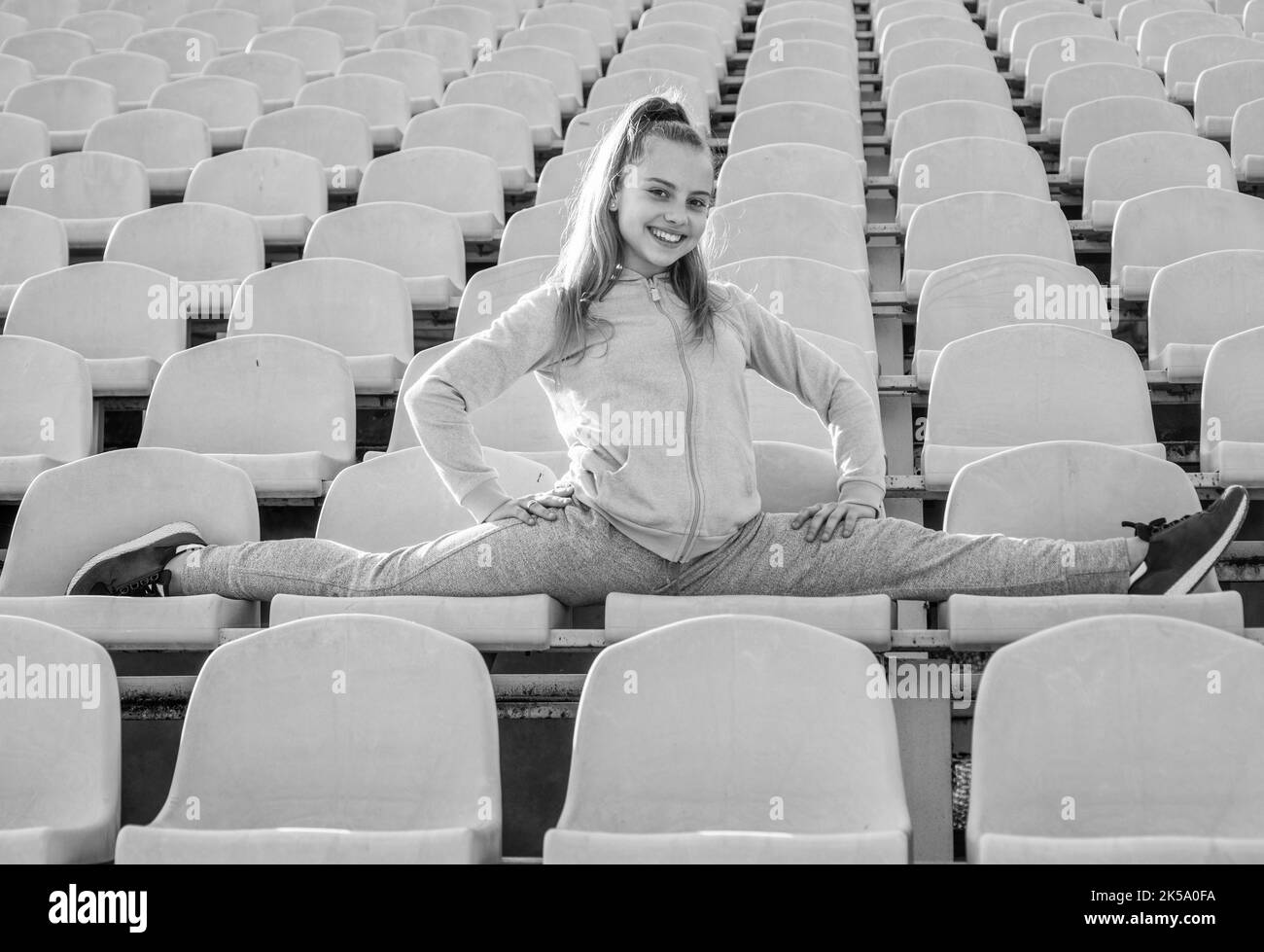 Stretch and flex for your health. Flexible tween do splits on stadium ...