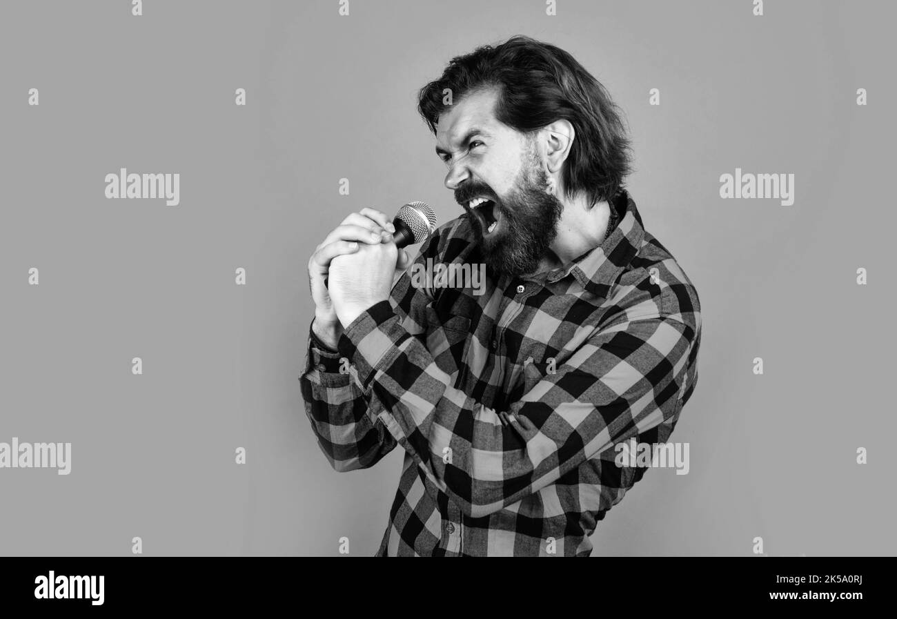 brutal bearded male with stylish look singing in mic, singer Stock ...
