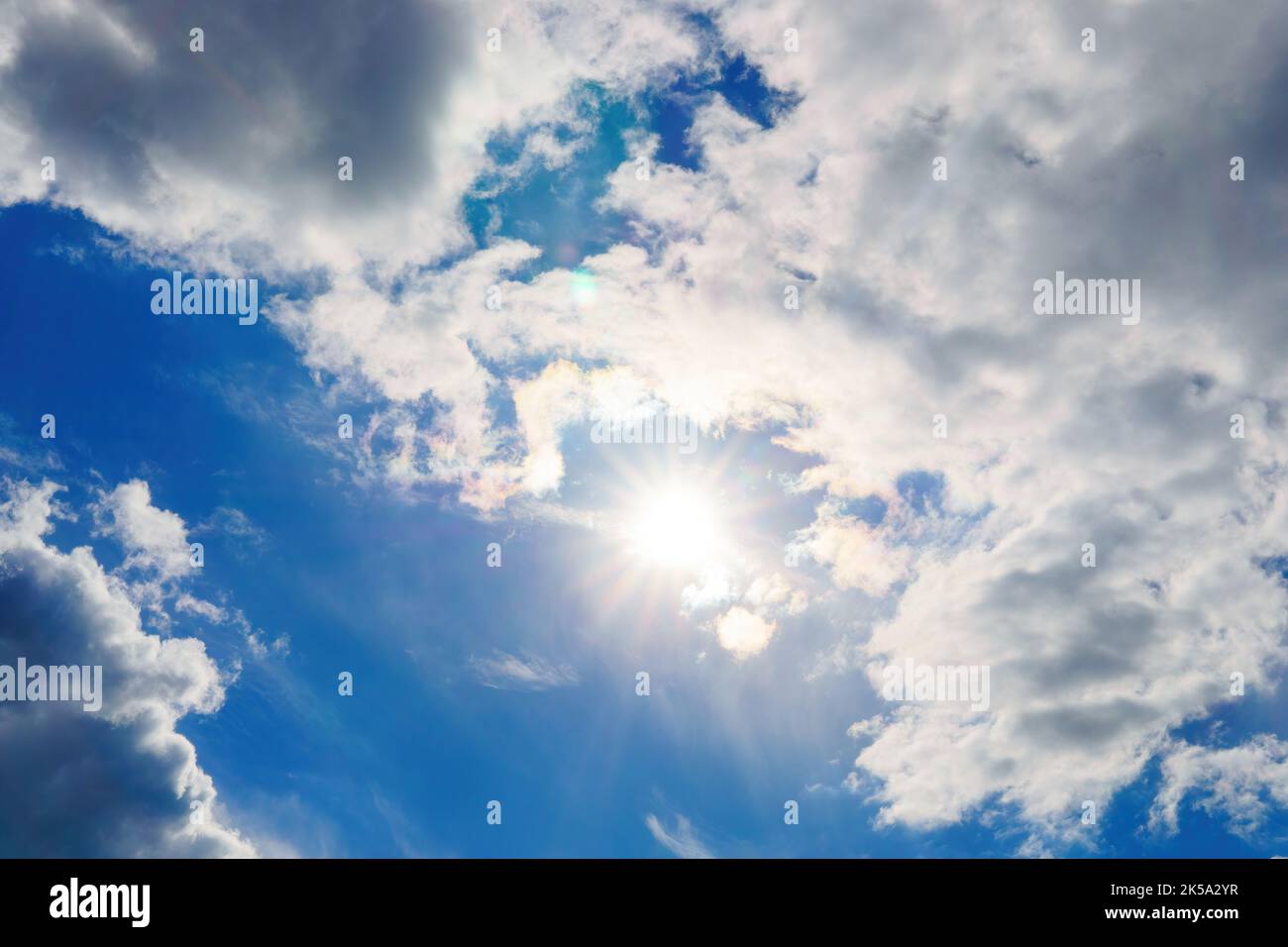 Sun breaks through the clouds in the blue sky on a windy day Stock ...