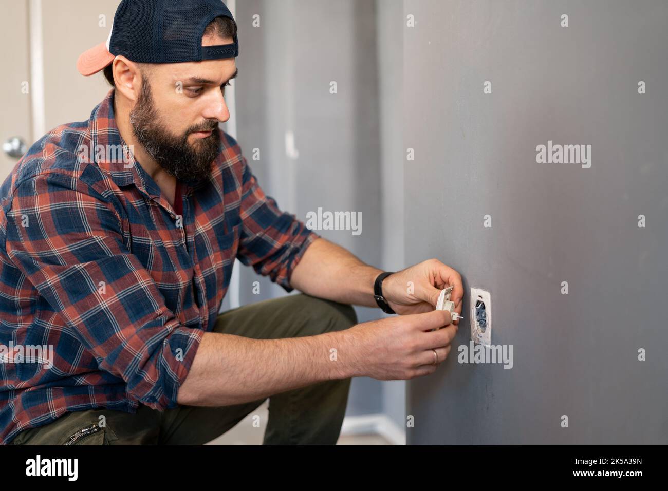 caucasian man electrician holding screwdriver working on the plug ...