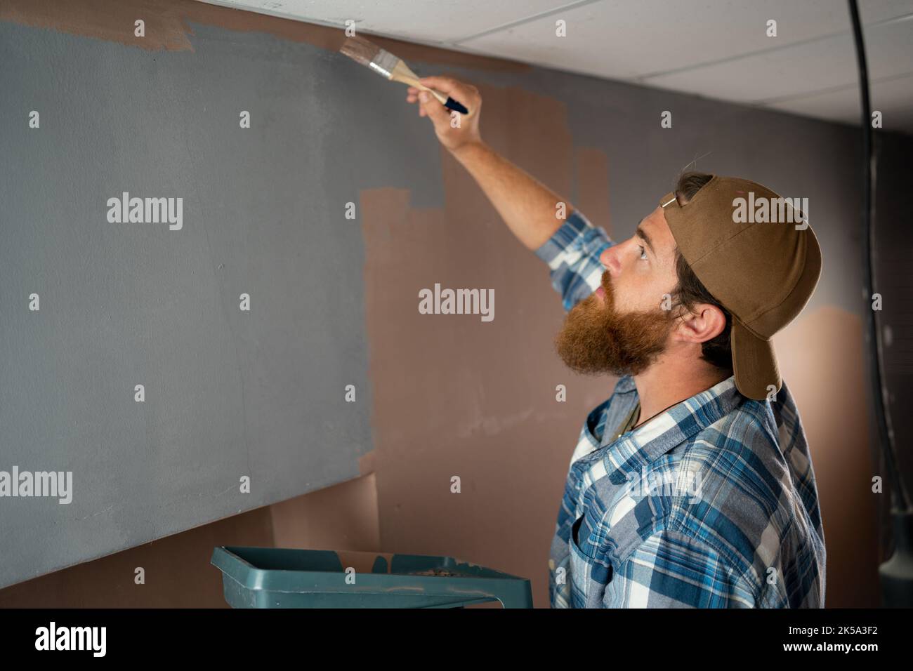 Male house painter painting ceiling with orange paint. repair and home ...