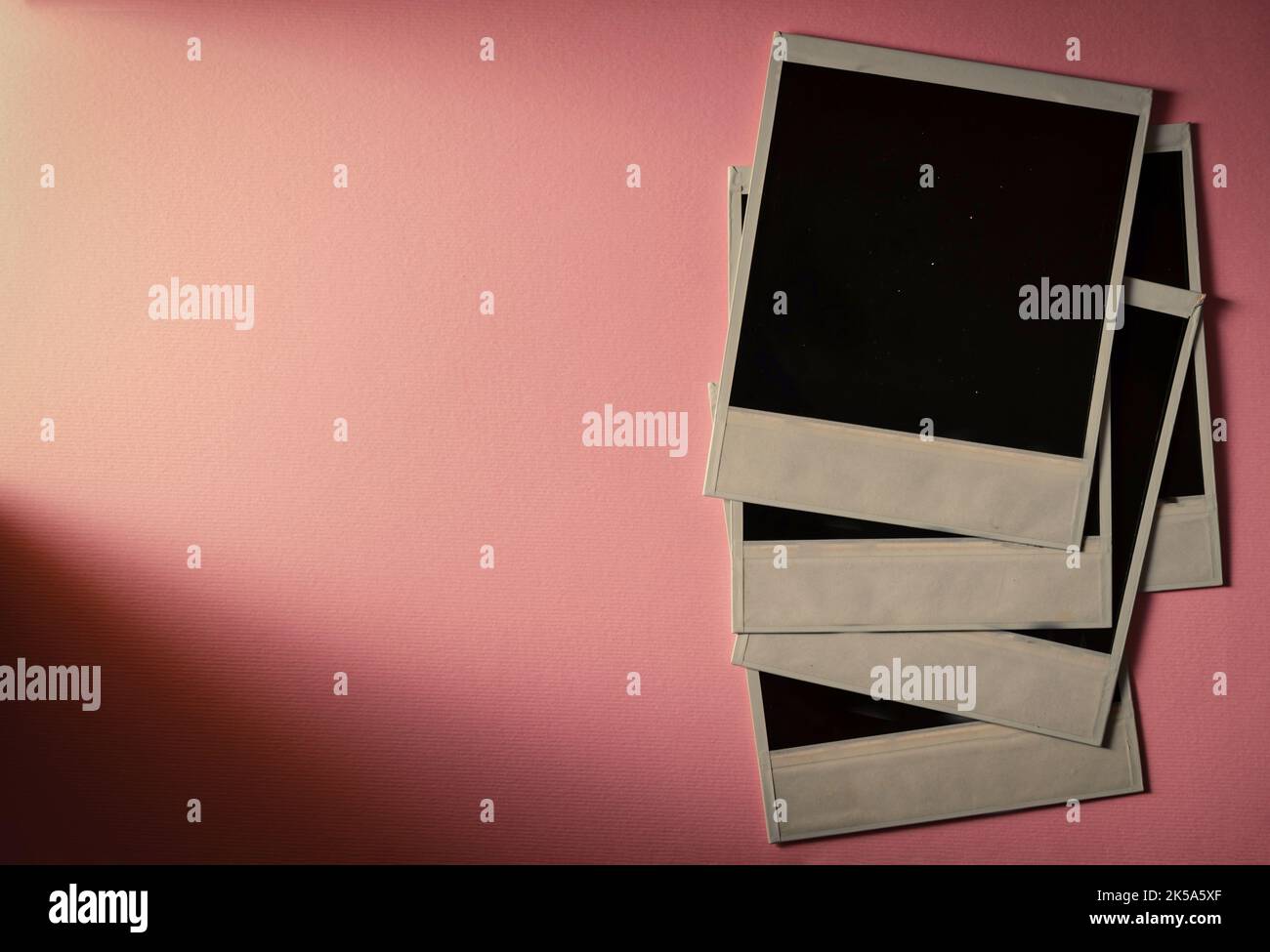 Stack of vintage photos. Blank photo frame on rose background Stock ...