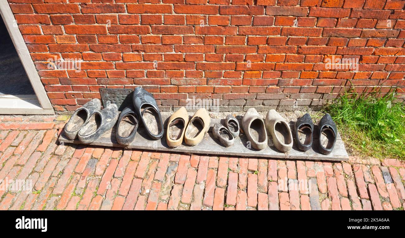 Vintage wooden shoes in front of a brick wall in the Netherlands, worn ...