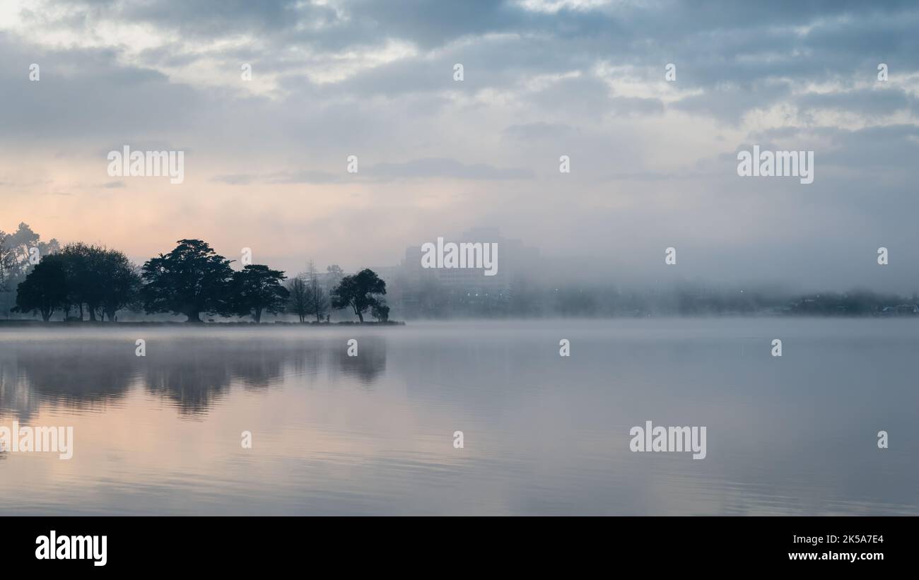 Lakeside buildings hidden in the fog at Hamilton lake (also known as ...