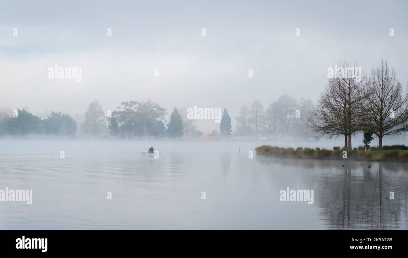 Man rowing a boat on the lake, heavy fog drifting on the lake Stock ...