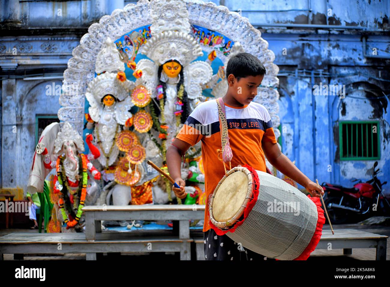 Serampore, India. 05th Oct, 2022. A kid plays a drum next to an idol of ...