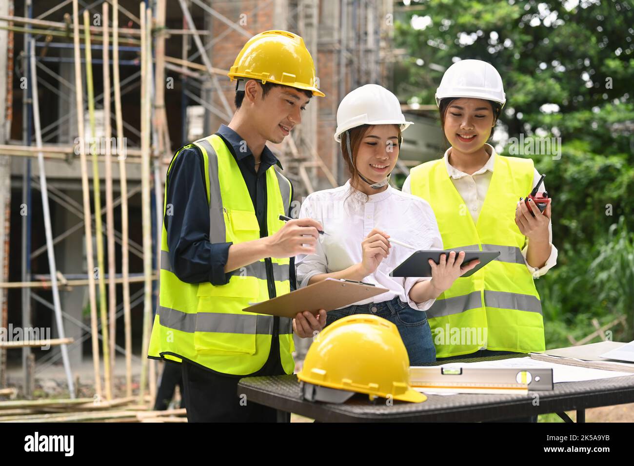 Engineer team and investor using digital tablet, discussing plan ...