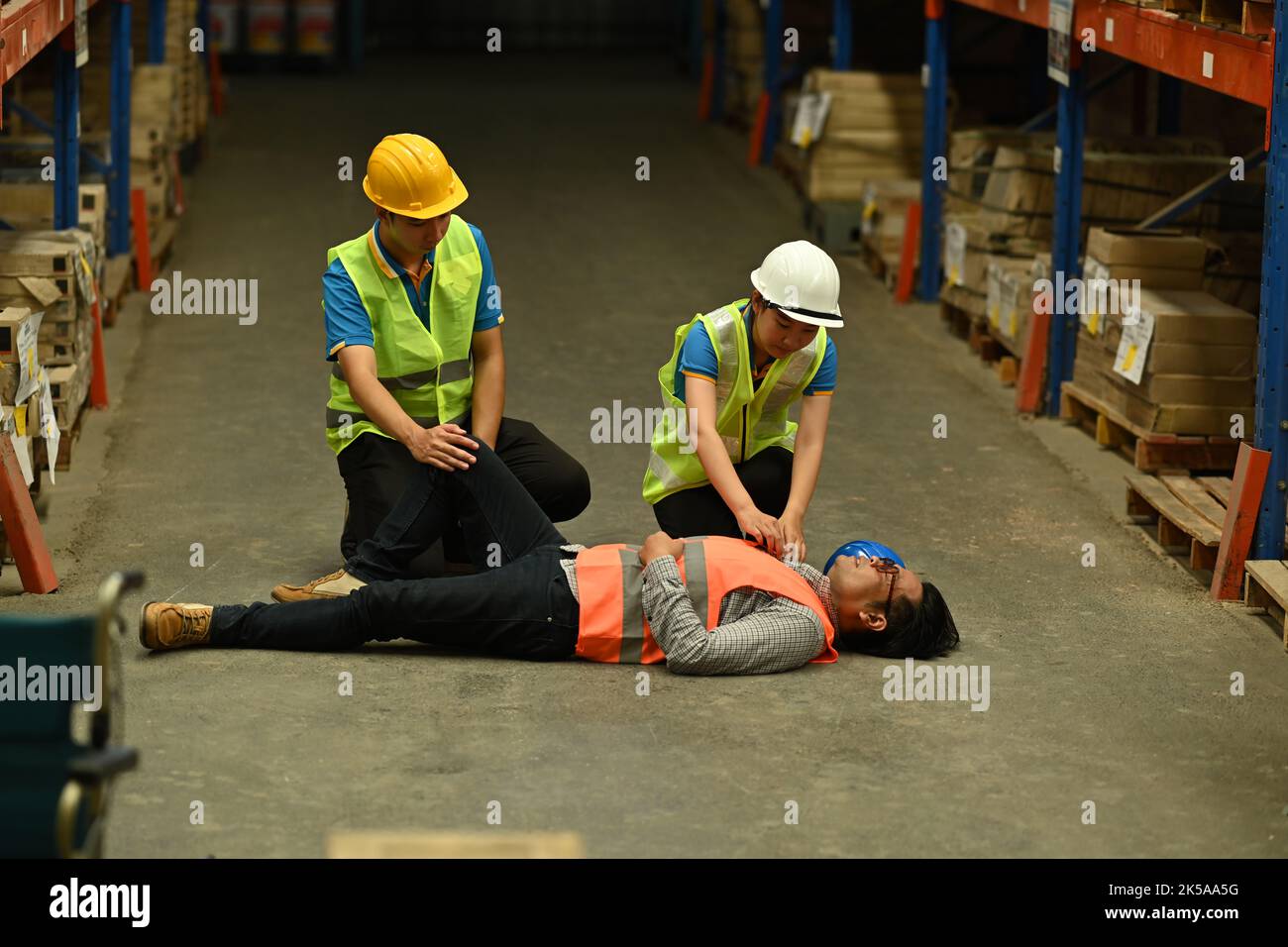 Man warehouse worker lying unconscious on the concrete floor ...