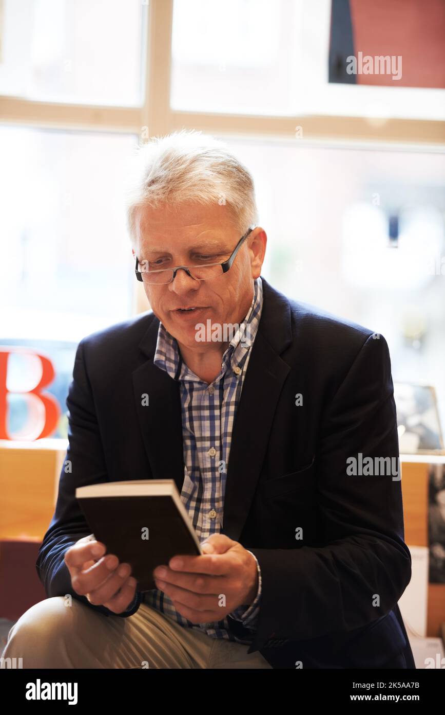 Reading is his favorite hobby. a senior man sitting and browsing ...