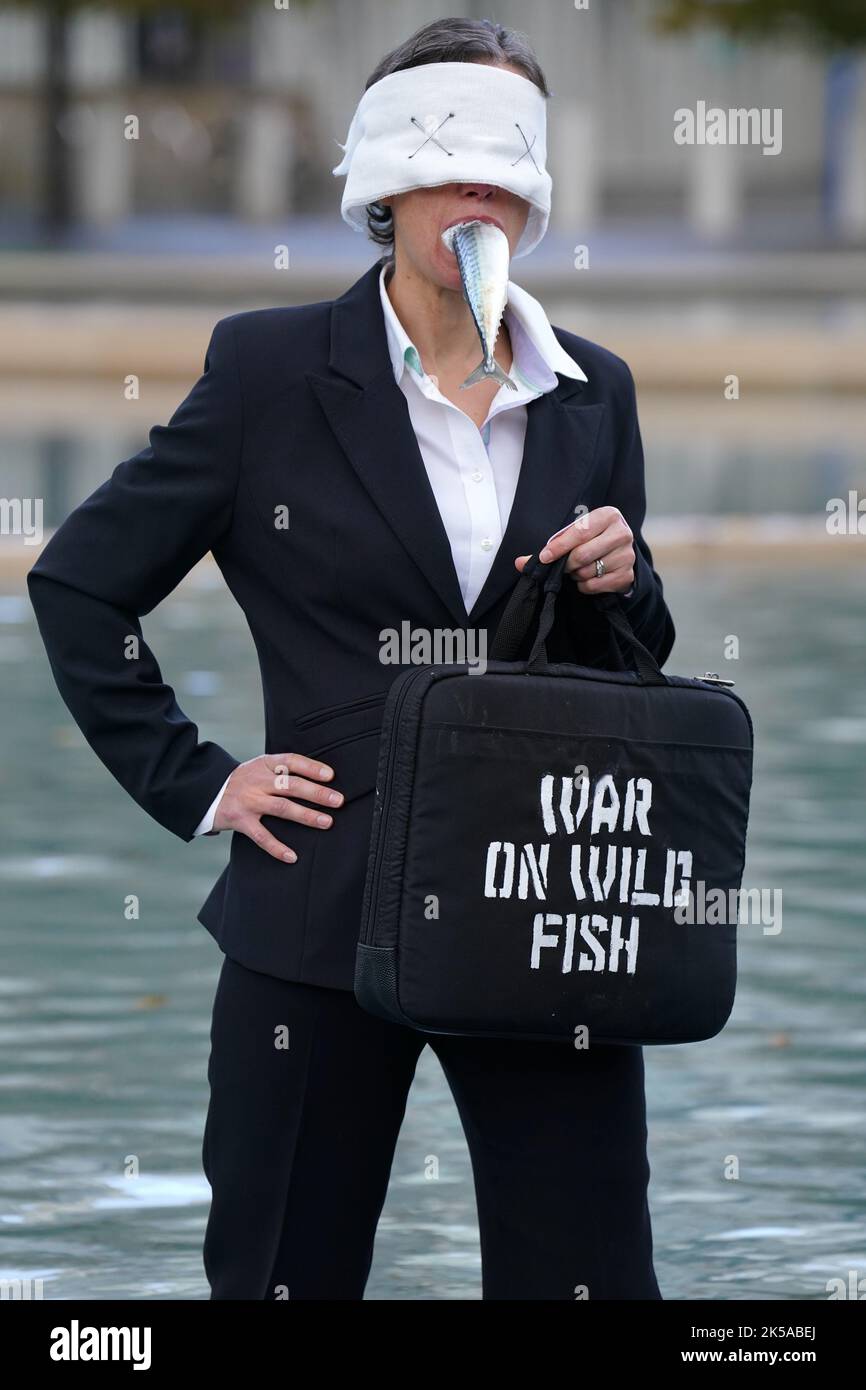 Suited performers from Ocean Rebellion, wearing blindfolds and gagged ...