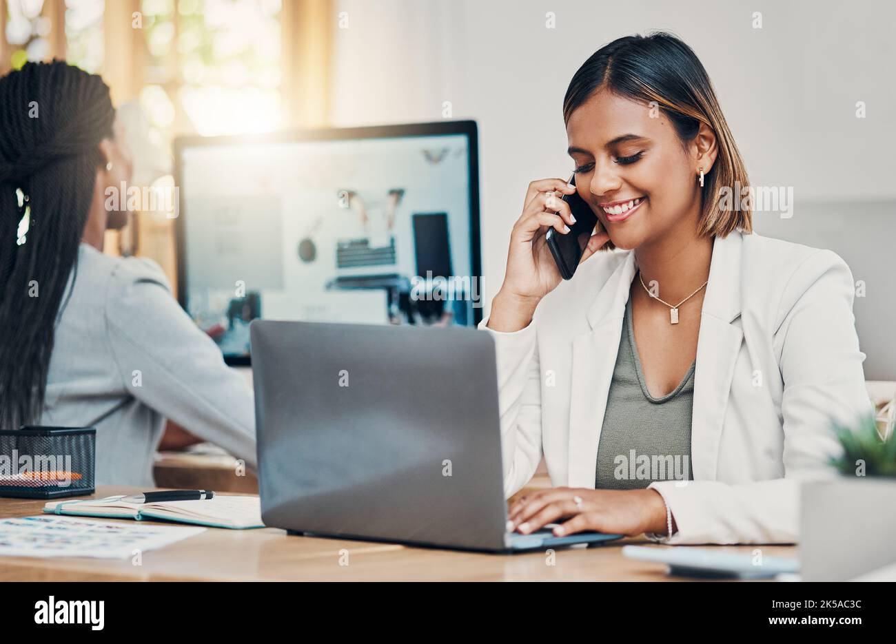 Phone, laptop and communication with a woman graphic designer talking ...