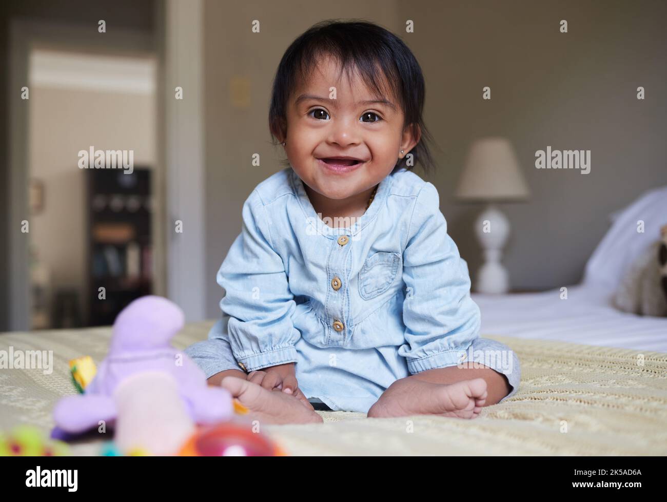 Down syndrome and happy baby portrait on bed with joy of Mexican ...