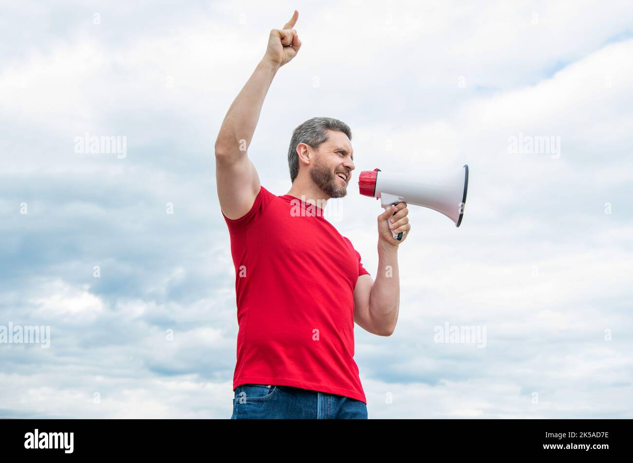 man in red shirt shout in loudspeaker on sky background. big sale Stock ...