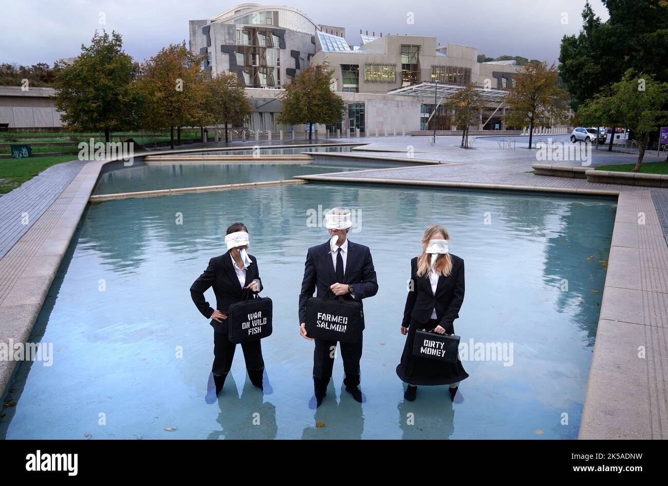 Suited performers from Ocean Rebellion, wearing blindfolds and gagged ...