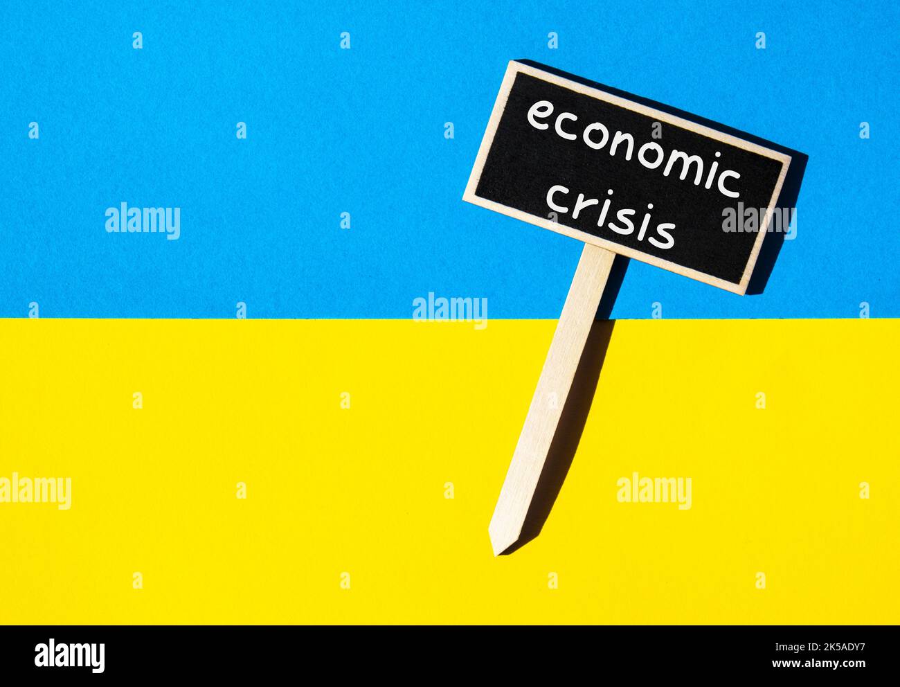 Wooden information label sign with text ECONOMIC CRISIS against ...