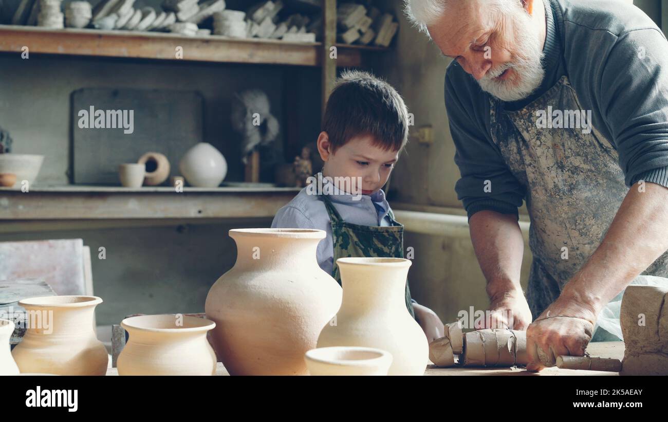 Experienced male potter is mixing and kneading clay while his cute ...