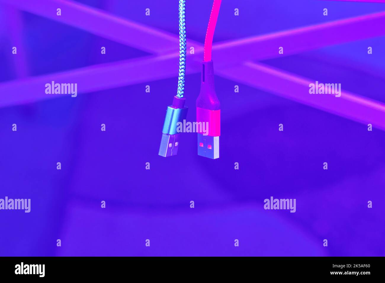 Connect and chat. Blue and red usb cables on pale purple background ...