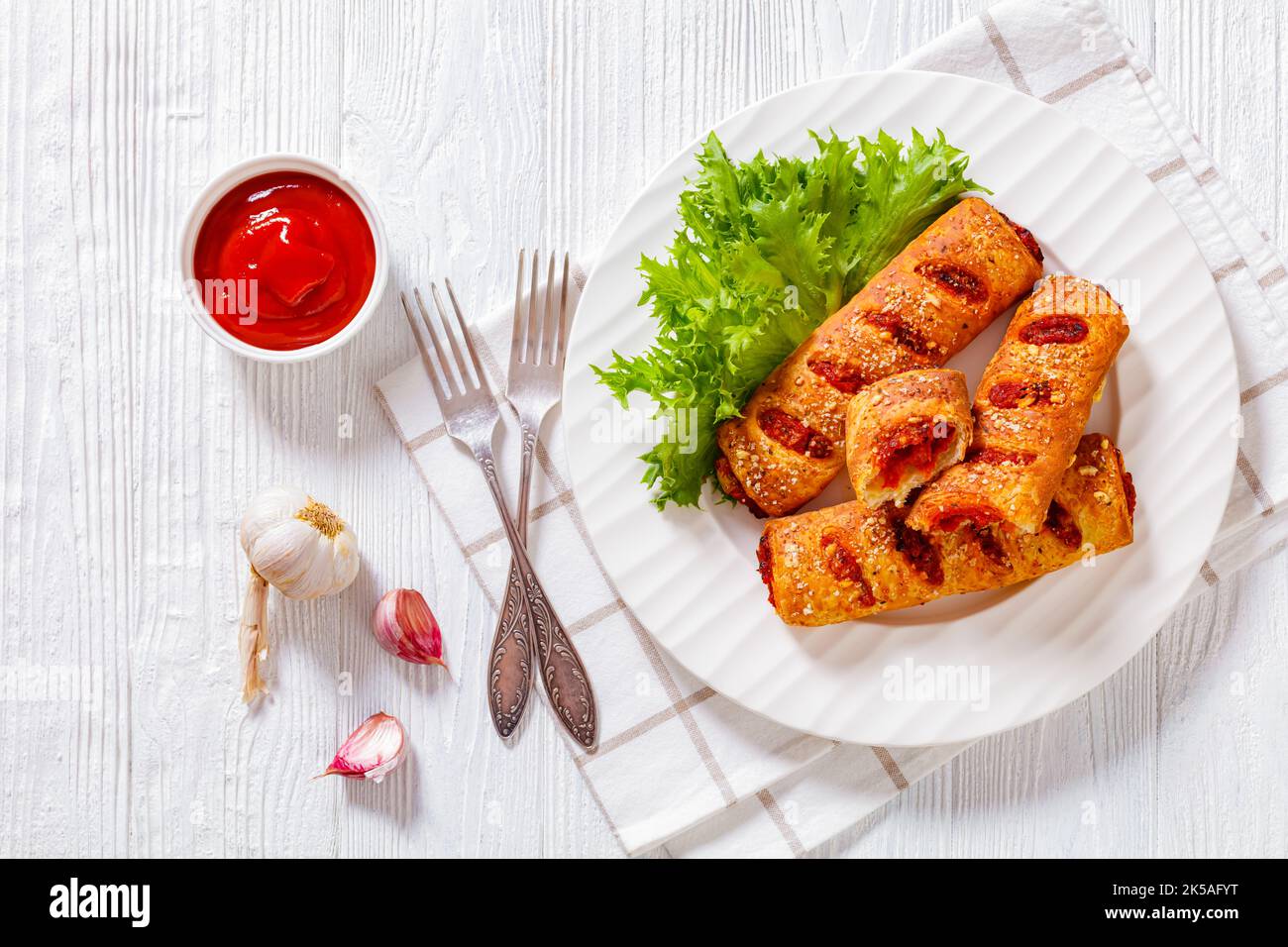 chorizo and semi-dried tomato puff pastry rolls on white plate with ...