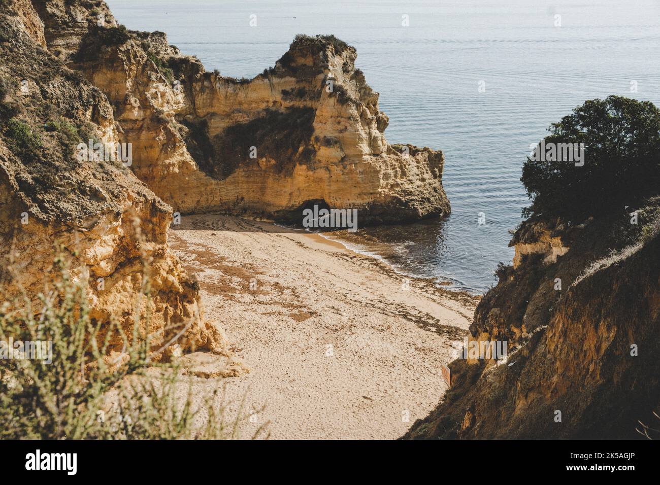 Empty and abandoned beach surrounded by cliffs on the coast of Algarve ...