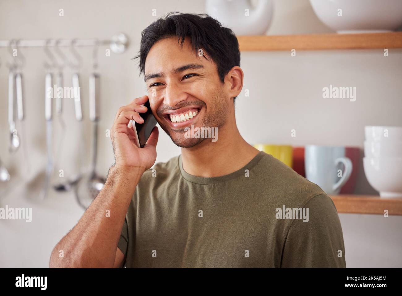 Happy man, phone call and communication in home kitchen for ...