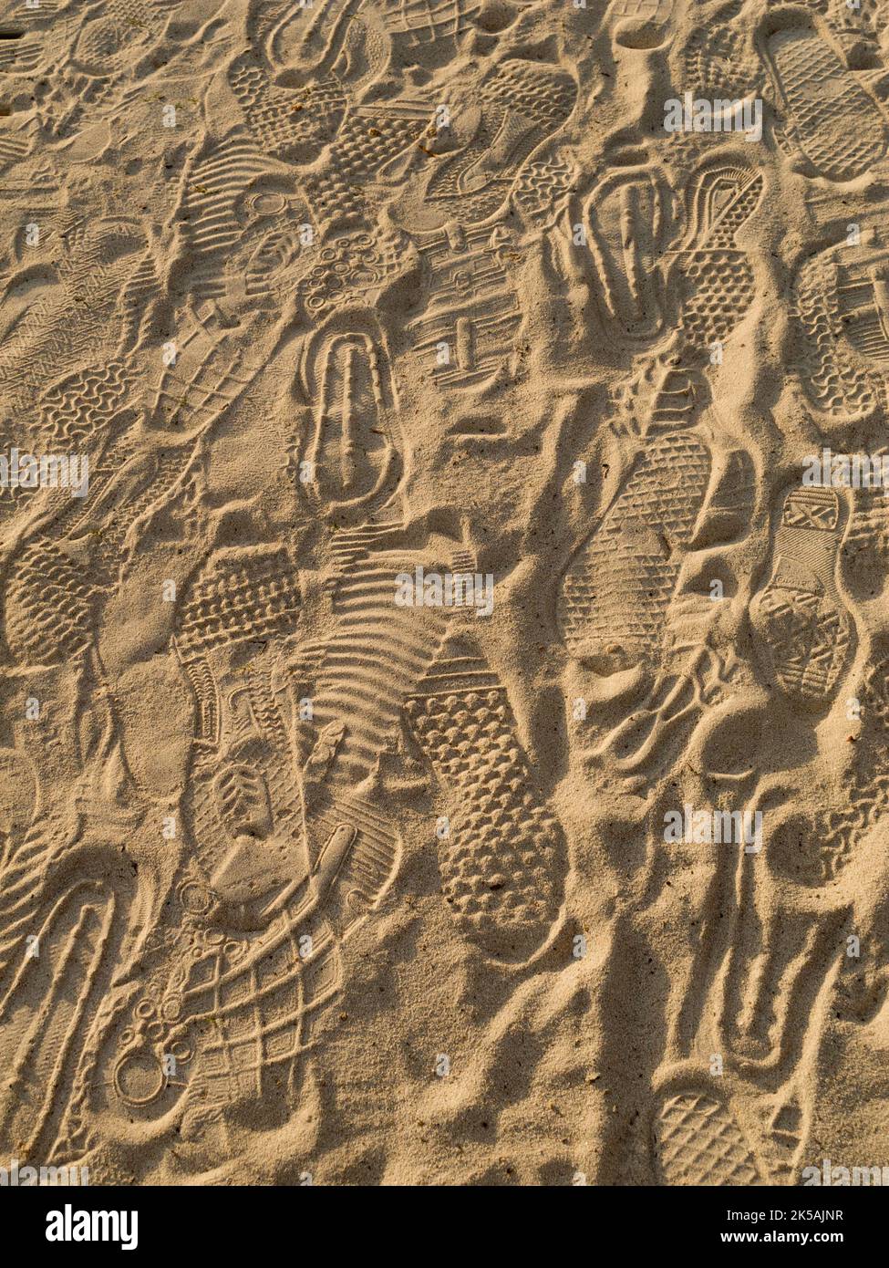 Sandy beach path covered in shoe and trainer footprints by holiday ...