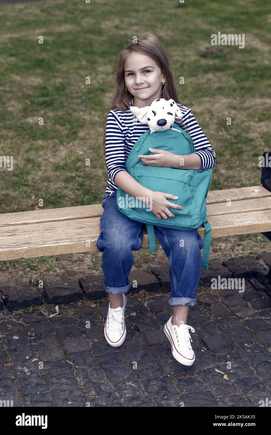 Play nice, stay kind. Preschool child hold toy dog in bag. Junior ...