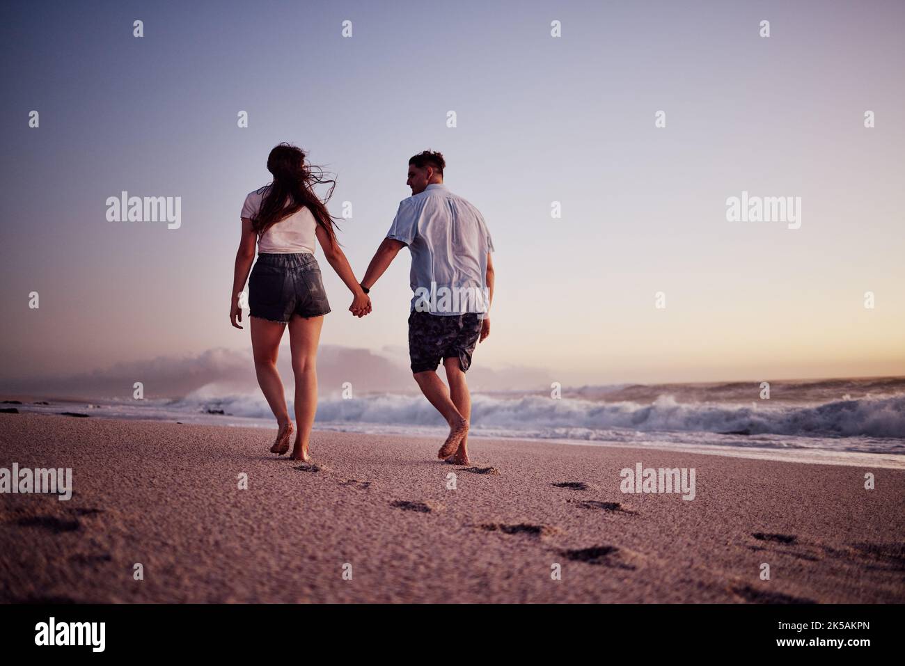 Love, holding hands and couple walking on the beach relax, bond and ...