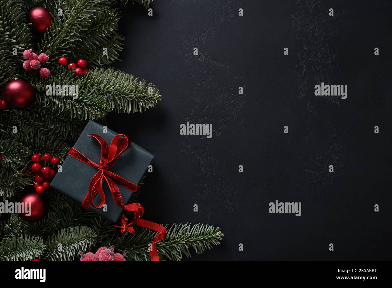 Christmas gift , red decorations, evergreen branches on black ...