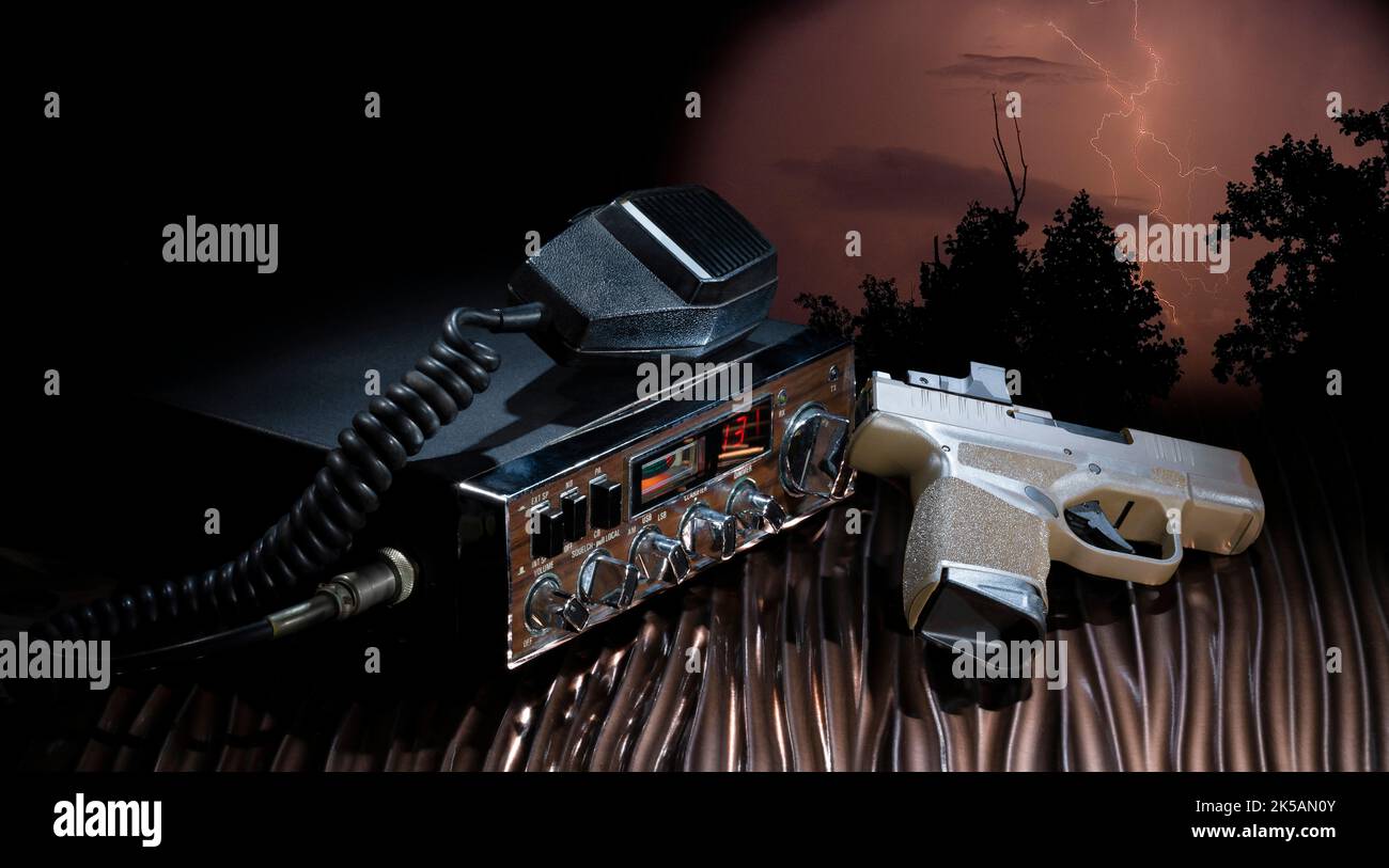 Two way radio and 9 mm pistol with lightning behind Stock Photo - Alamy