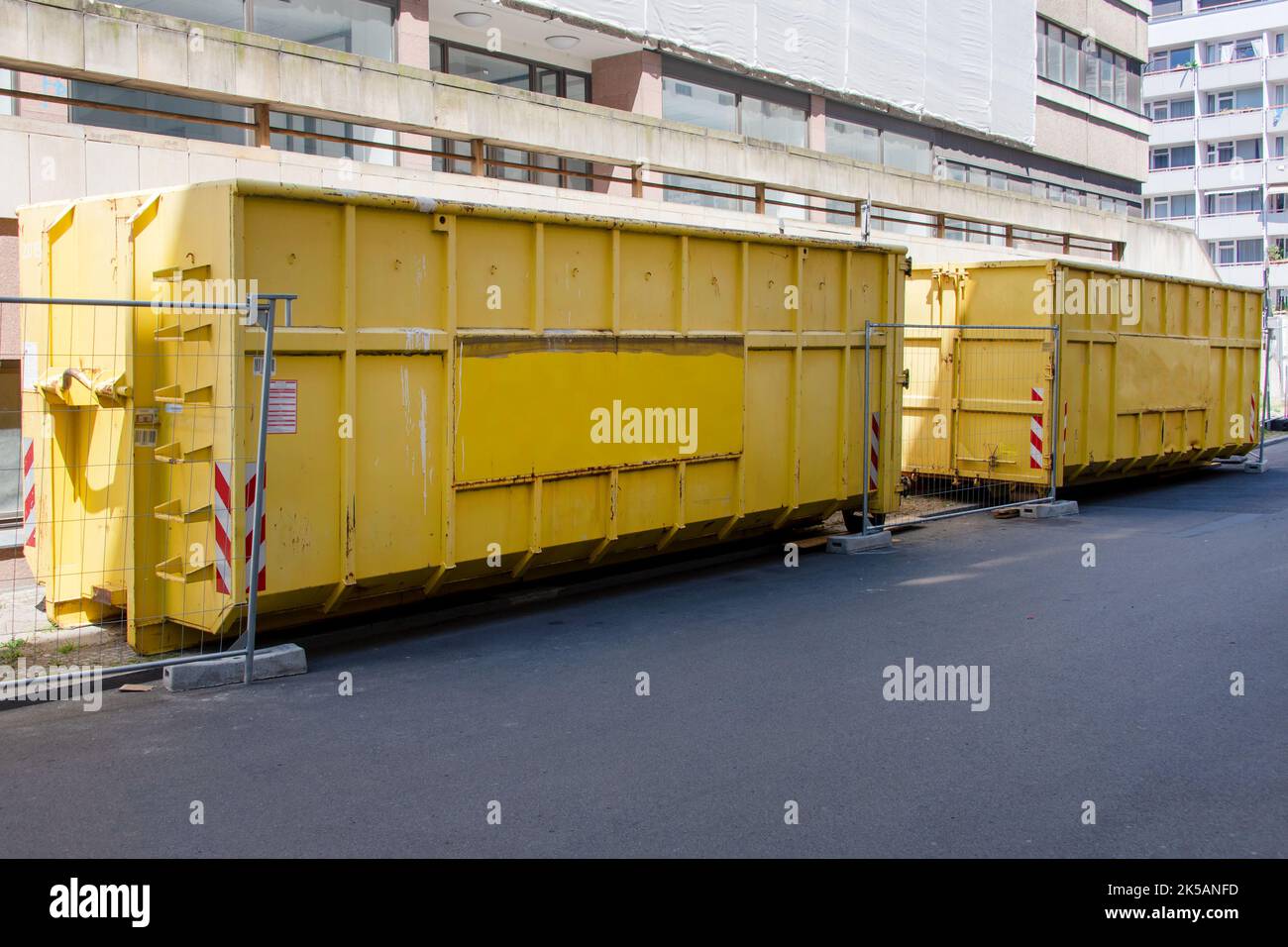 Yellow garbage containers near the building, construction site on the ...