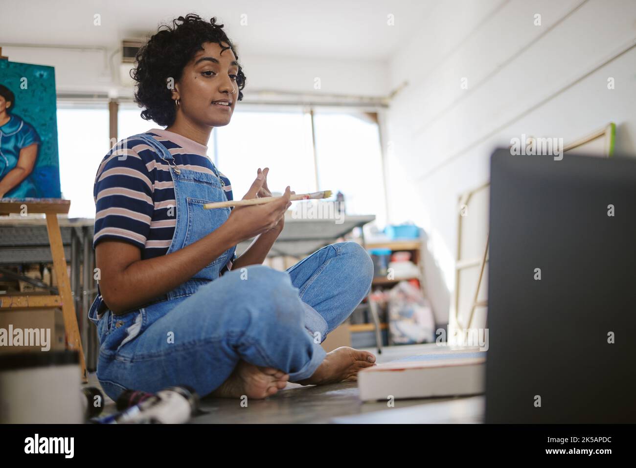 Woman artist, online class and laptop in art studio talking for video ...