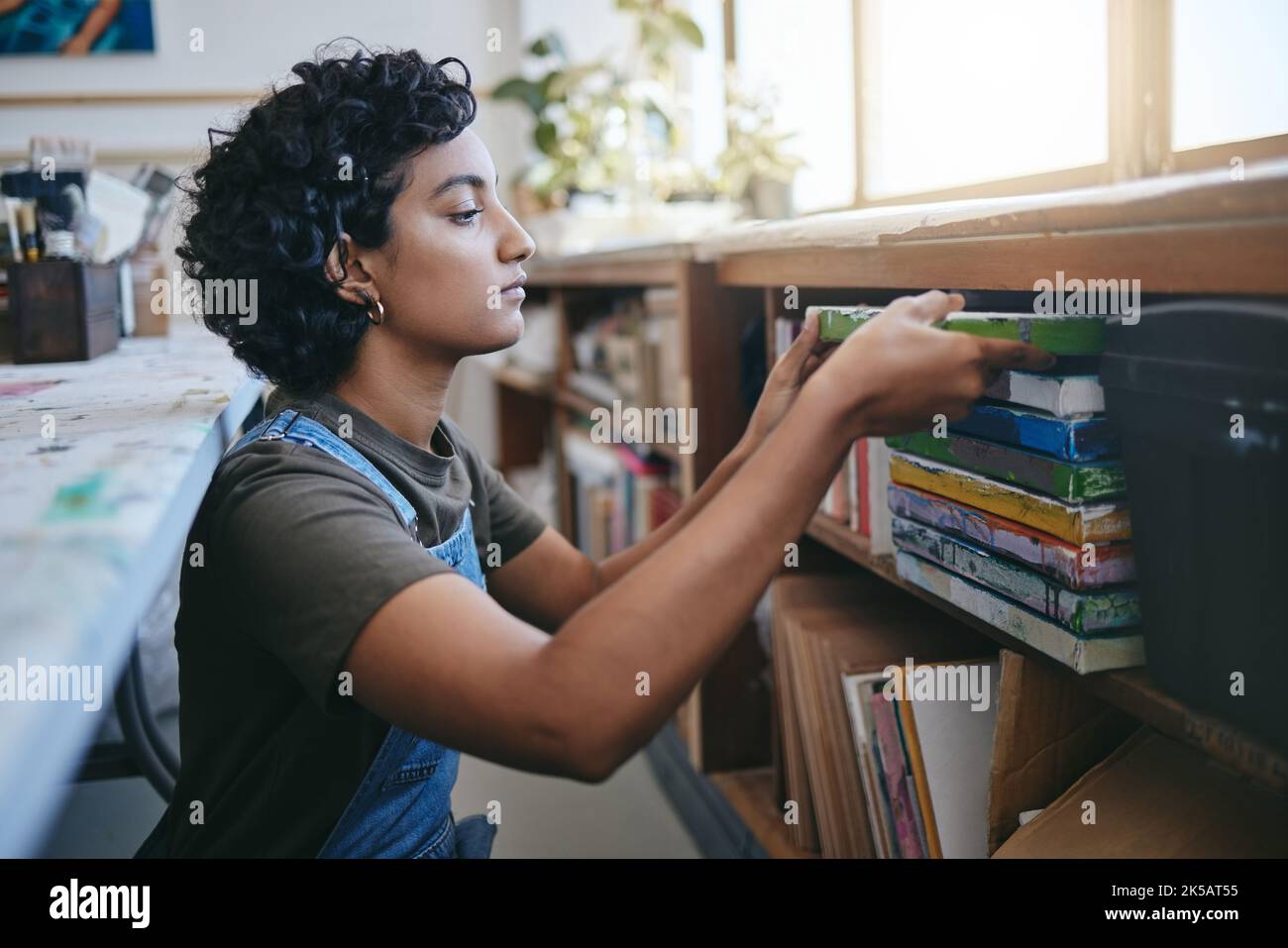 Creative, woman and art collection on shelf preparation and ...