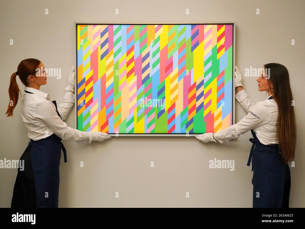 Technicians handle 'Summer Shades' by Bridget Riley during the preview ...
