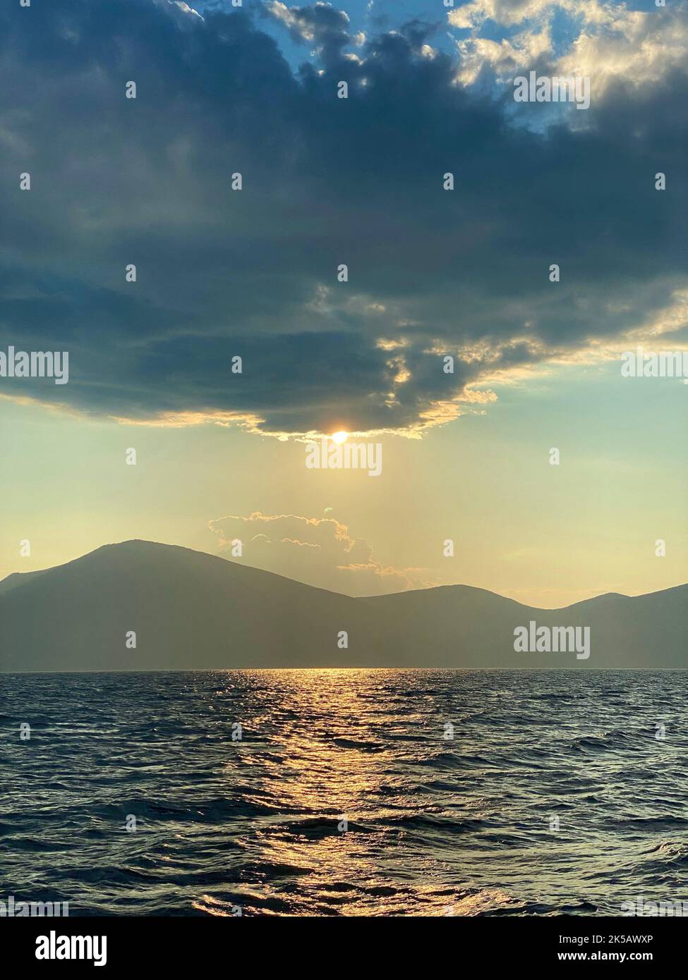 A vertical of a calm seascape under a cloudy sky captured under ...