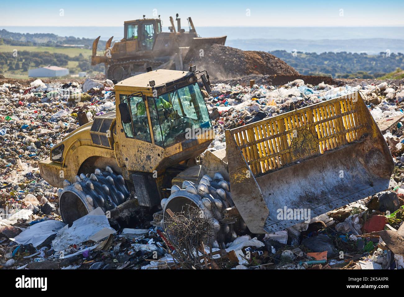 Heavy machinery shredding garbage in an open air landfill. Waste Stock ...