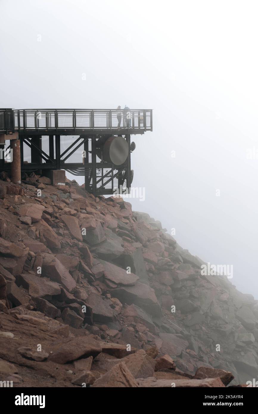 The edge of metal bridge over stones of pikes peak in Colorado under a ...