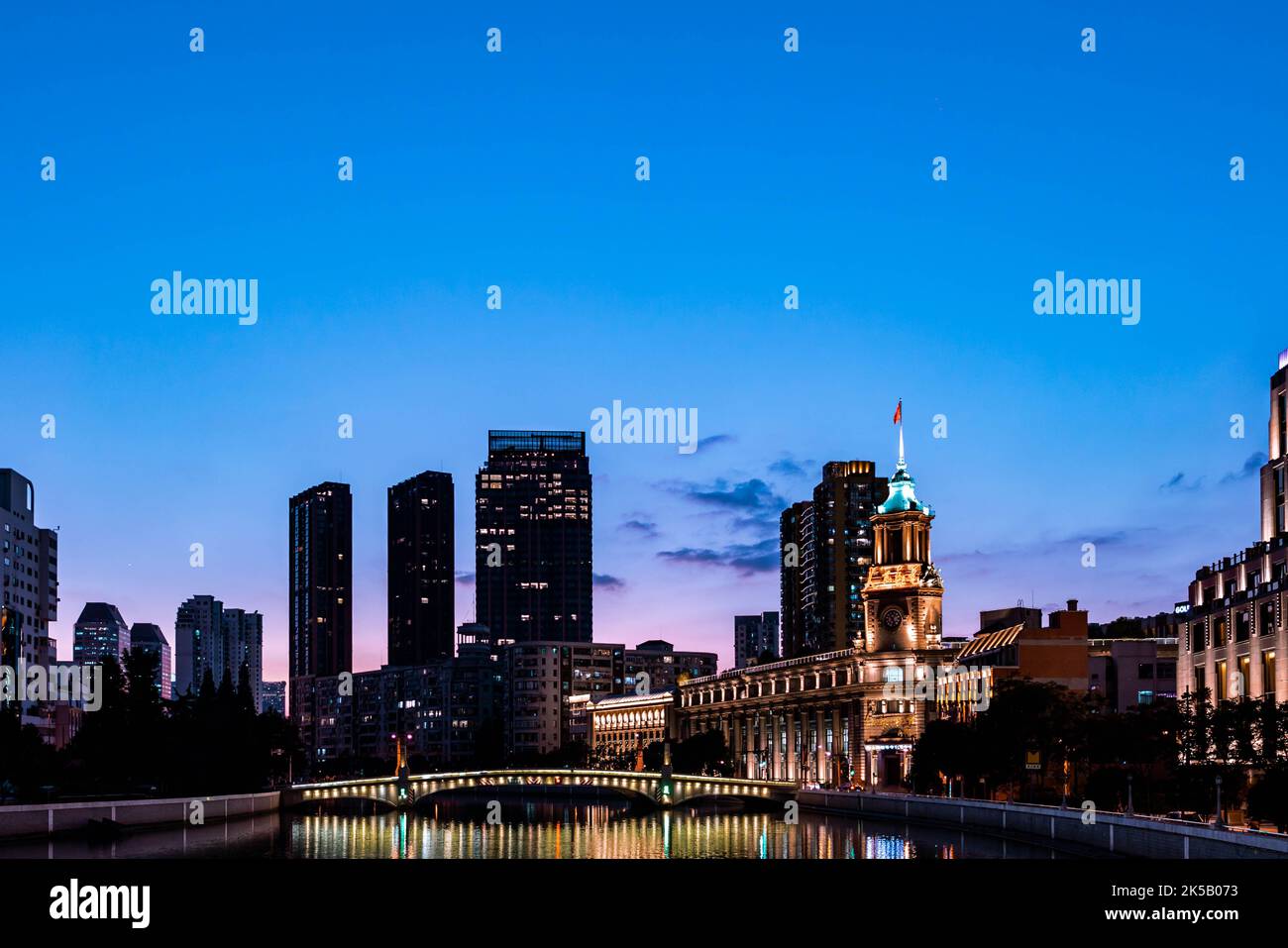 A beautiful view of modern high buildings with lights under the clear ...