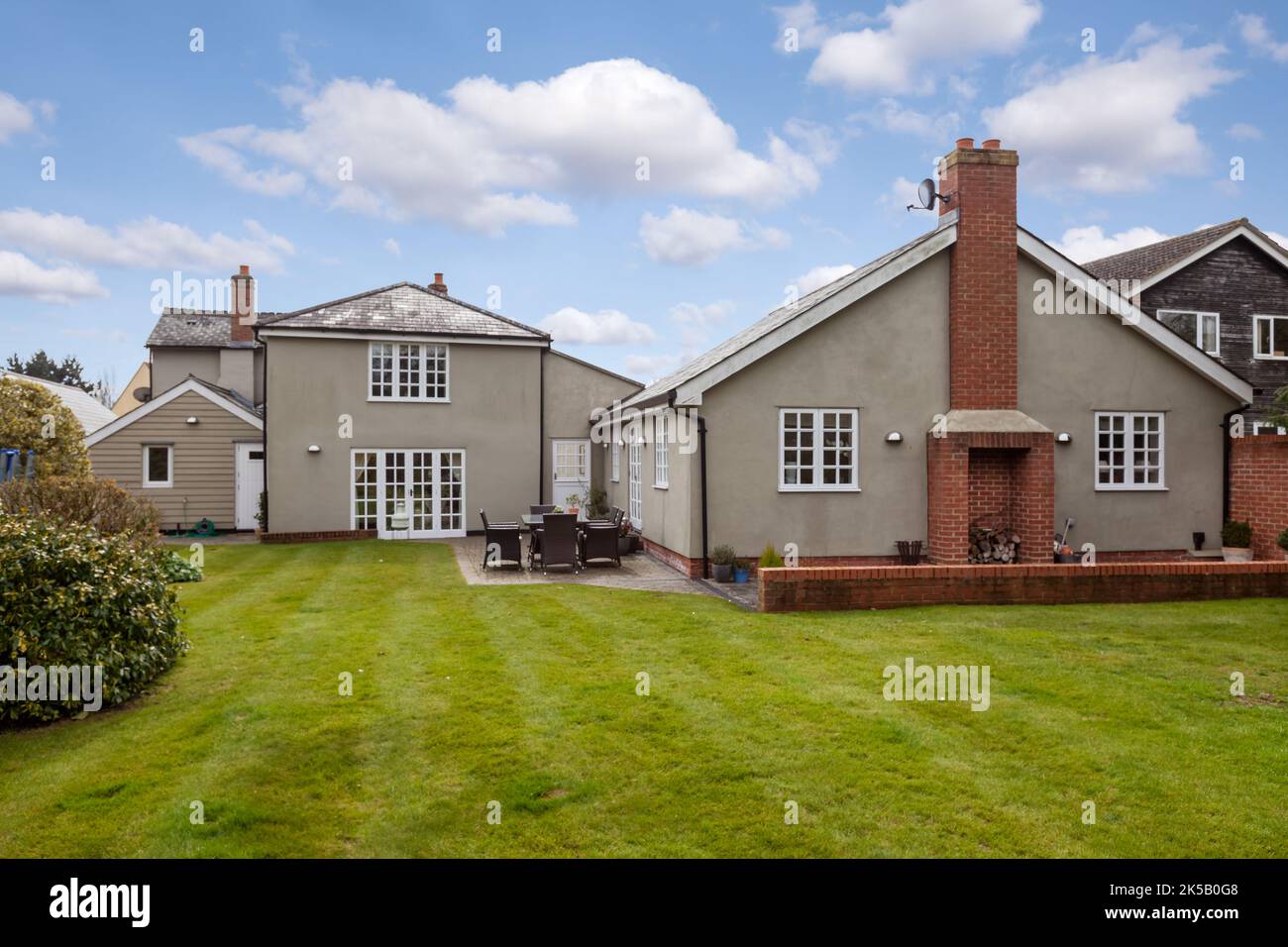 Extended traditional detached cottage from rear with lawn and patio ...