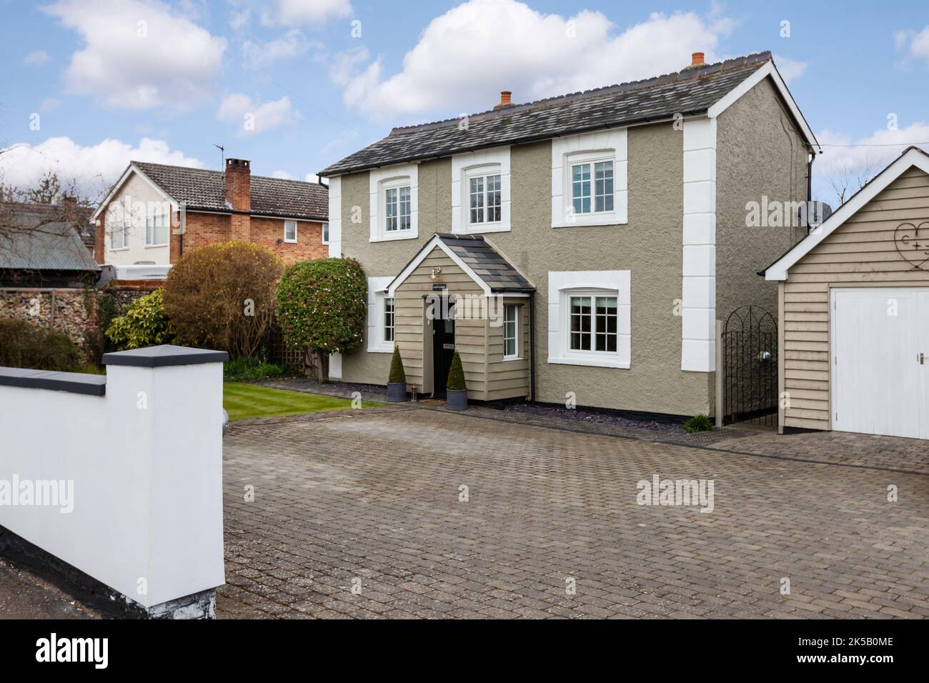 Detached traditional cottage with paved driveway and garage Stock Photo ...