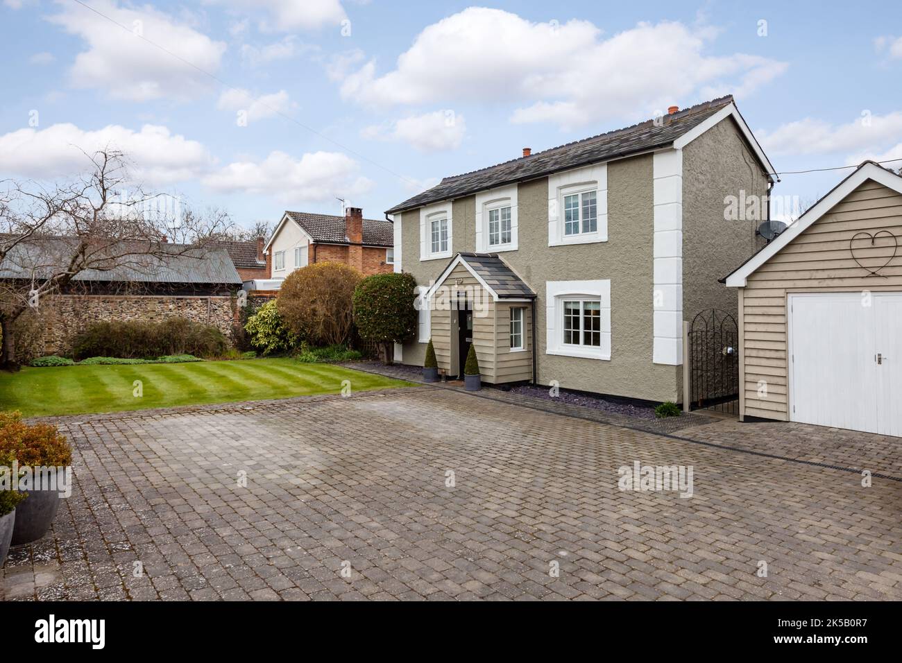 Detached traditional cottage with paved driveway and garage Stock Photo ...