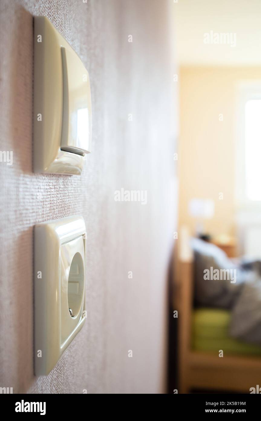 light switch and electrical outlet hanging on the wall of the living ...