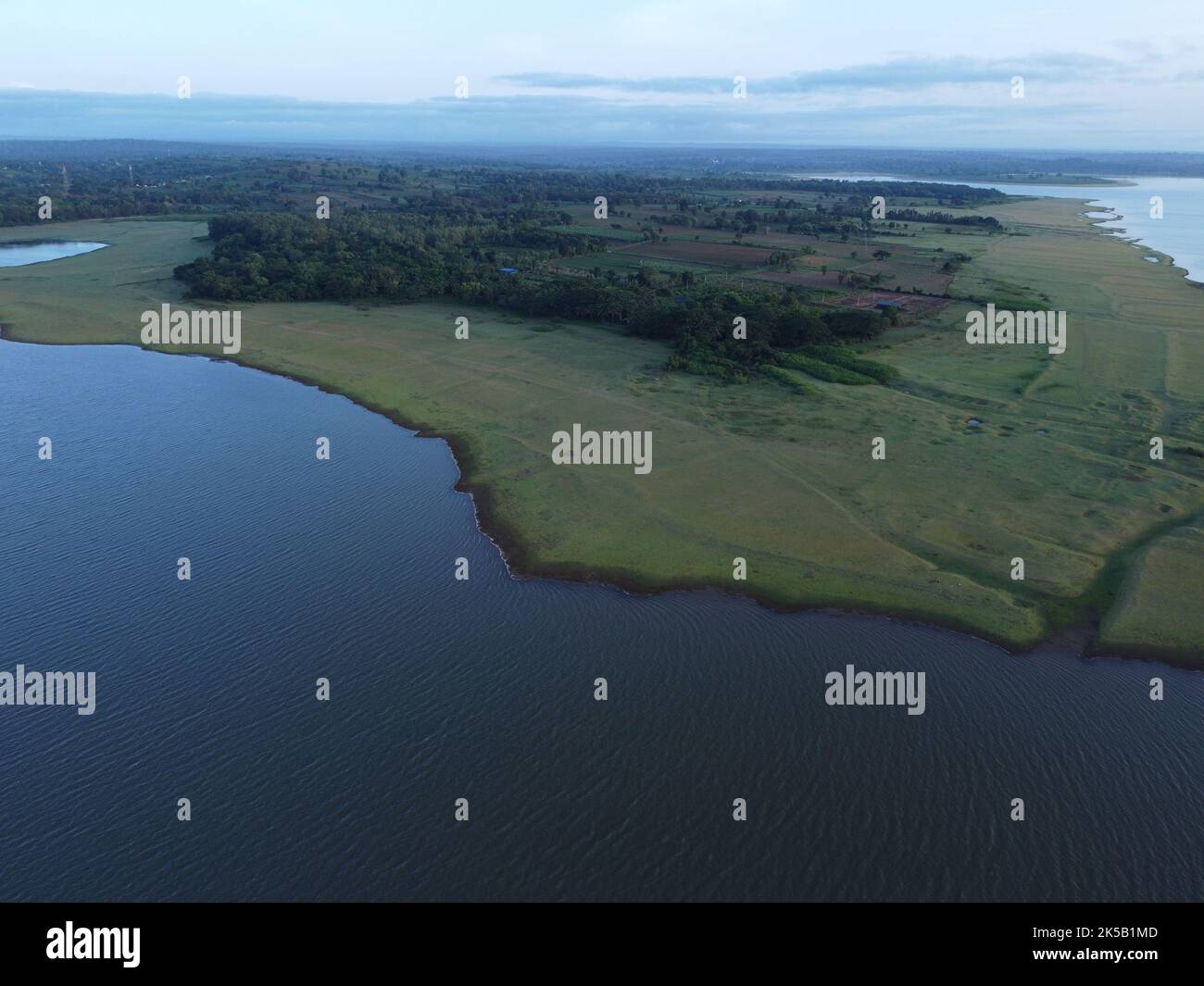 An aerial view of lake by trees and agricultural fields Stock Photo - Alamy