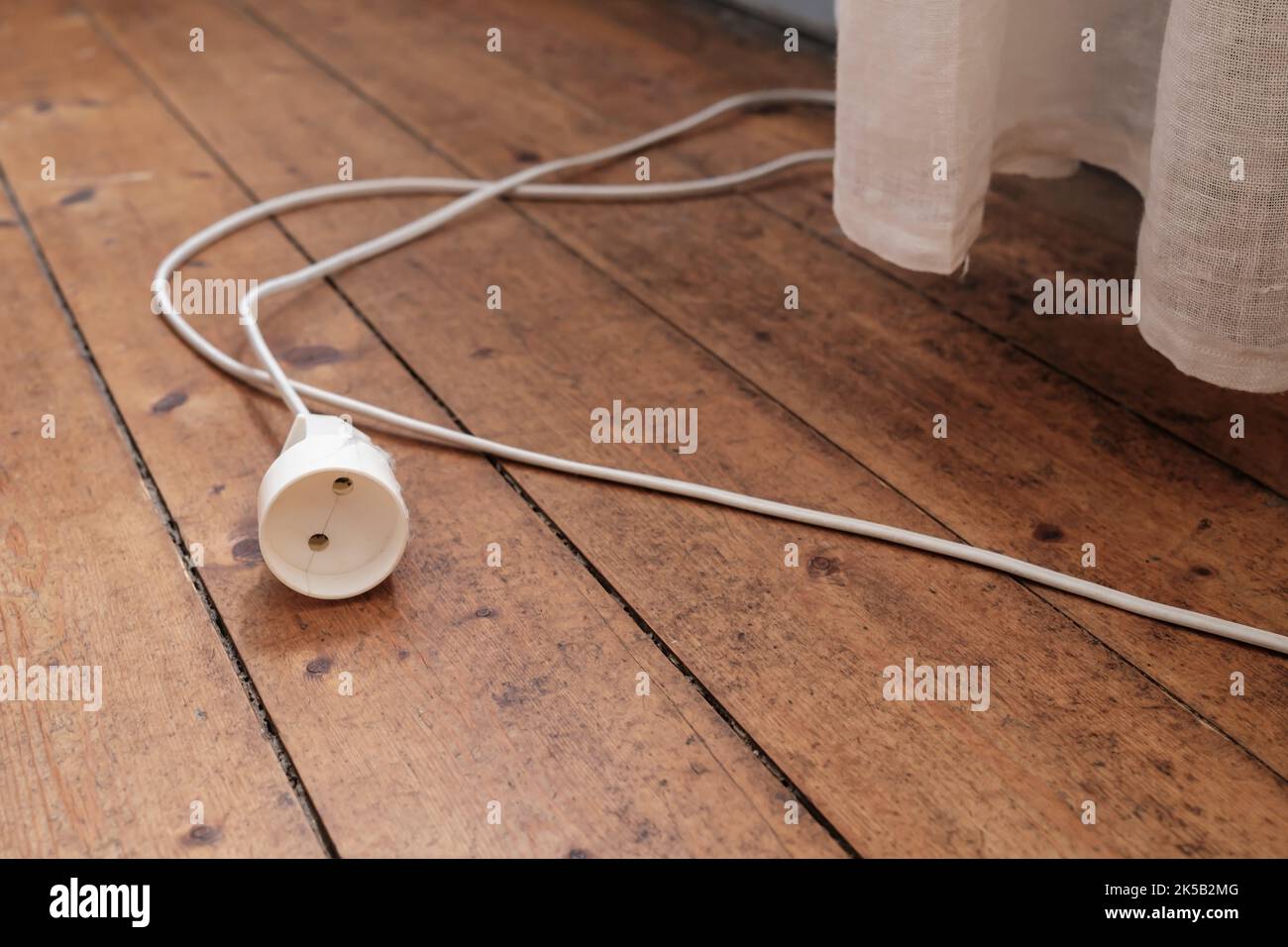 authentic electrical extension cord lies on an old vintage wooden floor ...