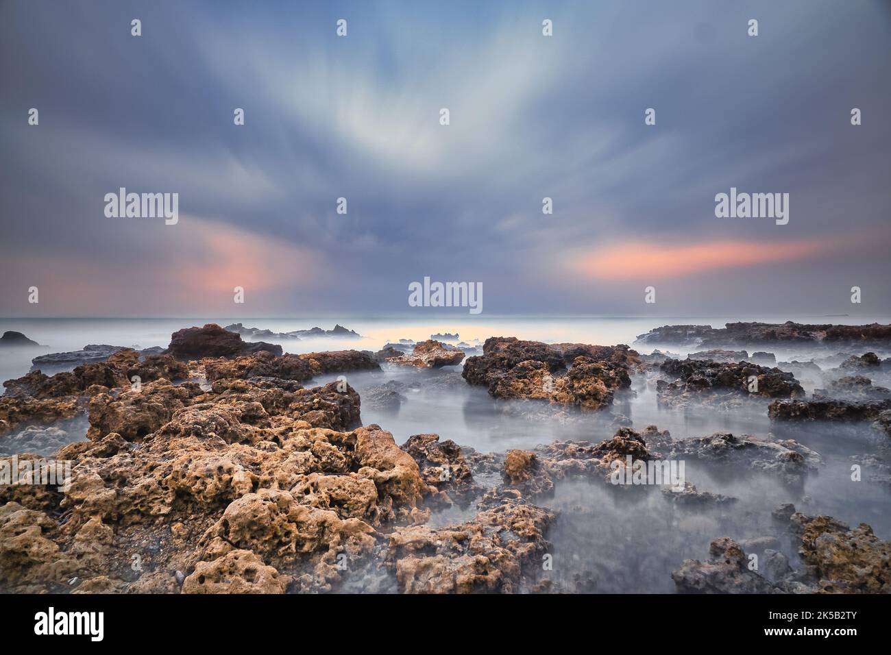 A beautiful scenery of a coast with rocks in a late sunset sky ...