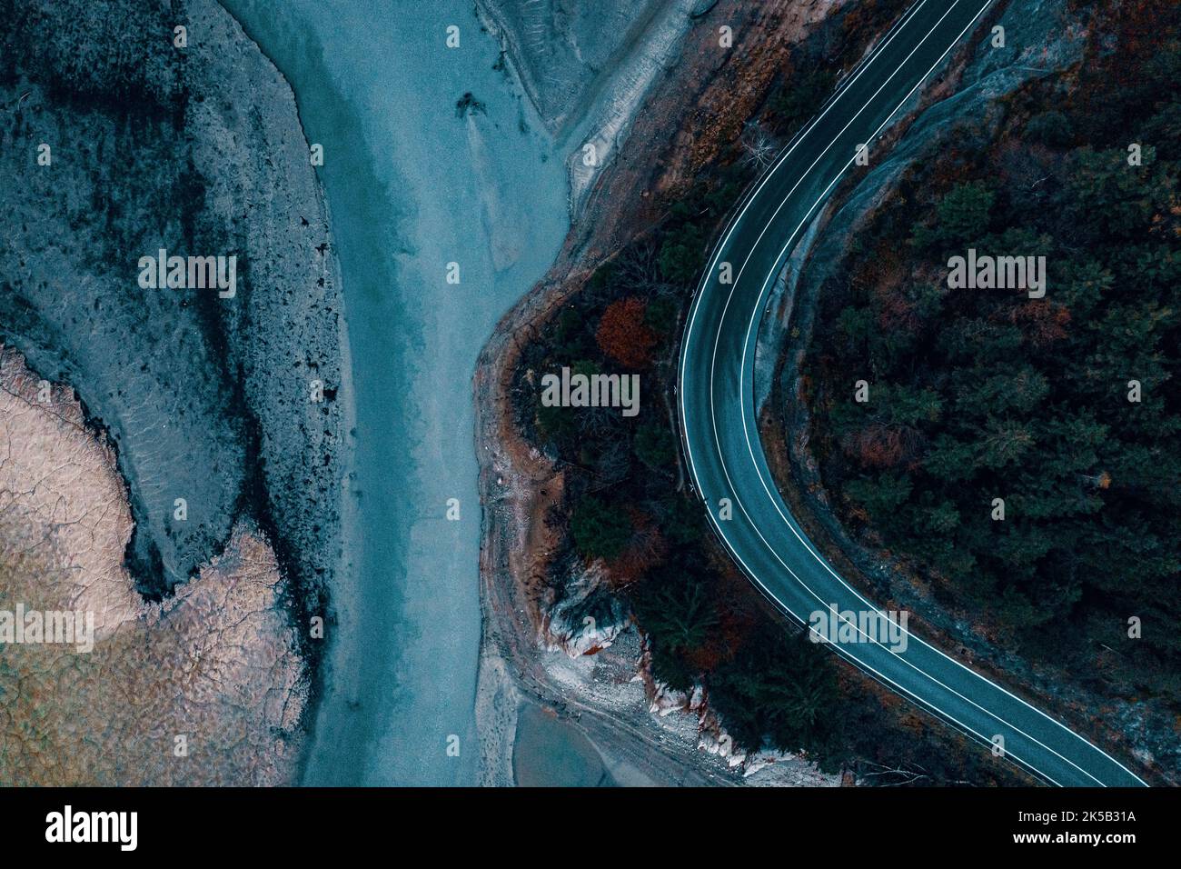 An aerial view of droughty water area and winding asphalt road in ...