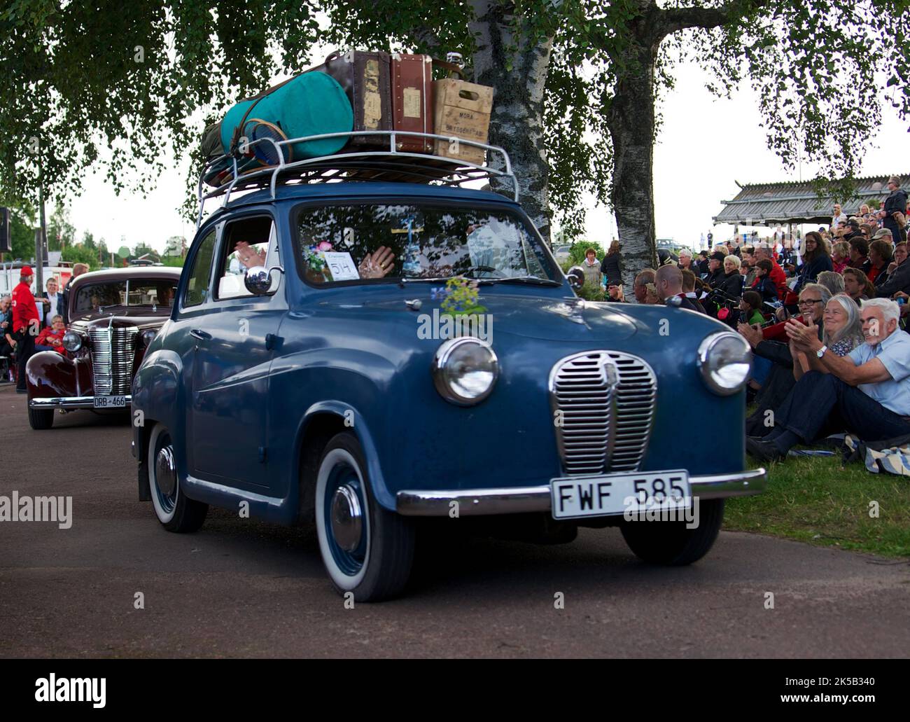 A vintage Austin A30 small blue car with round headlights and suitcases ...