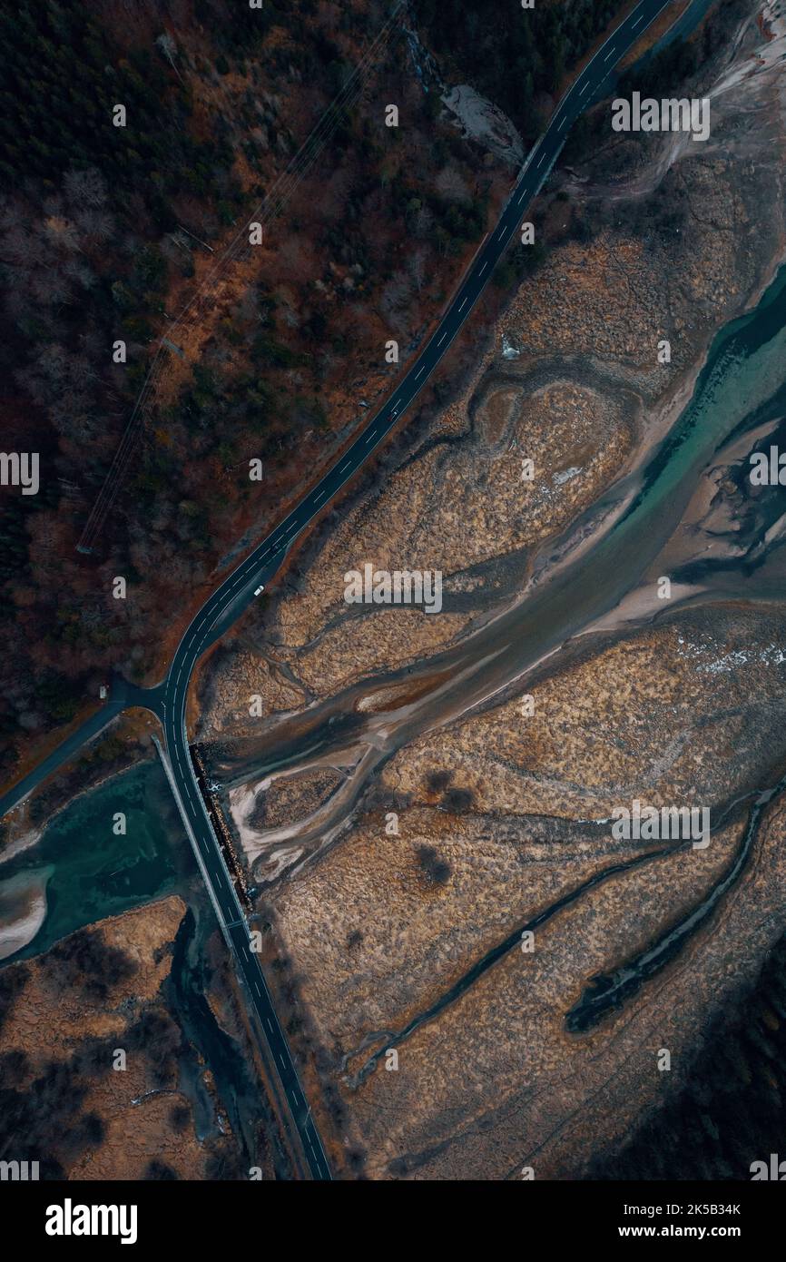 A vertical nature view of a blue crystal river under mountains from ...